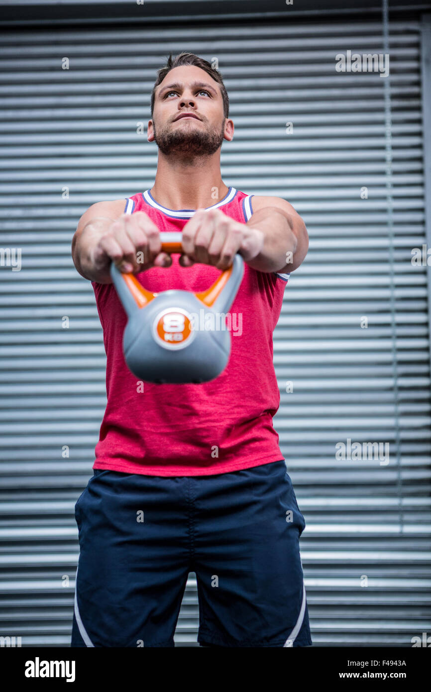 Muscular man lifting a kettlebell Stock Photo - Alamy