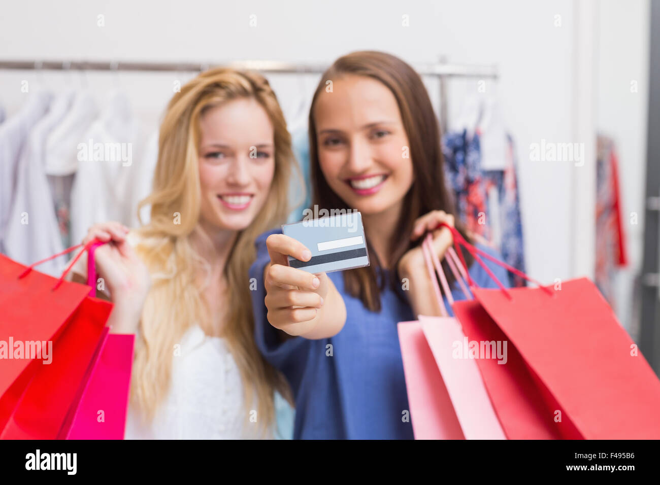 Happy friends handing a credit card Stock Photo - Alamy