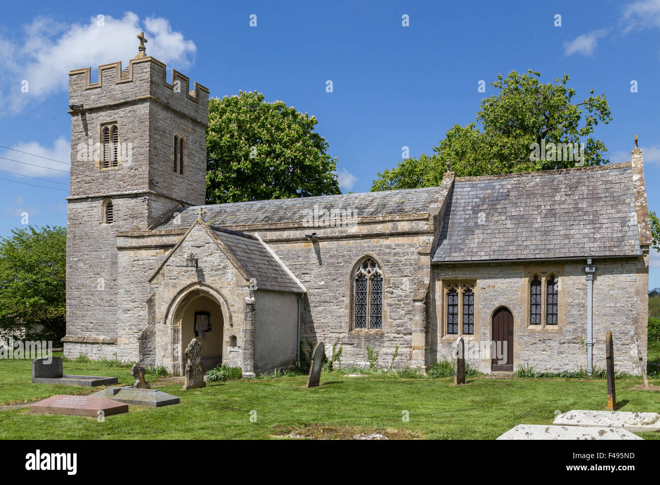 North Bradley Church and graveyard in Spring against green grass and ...