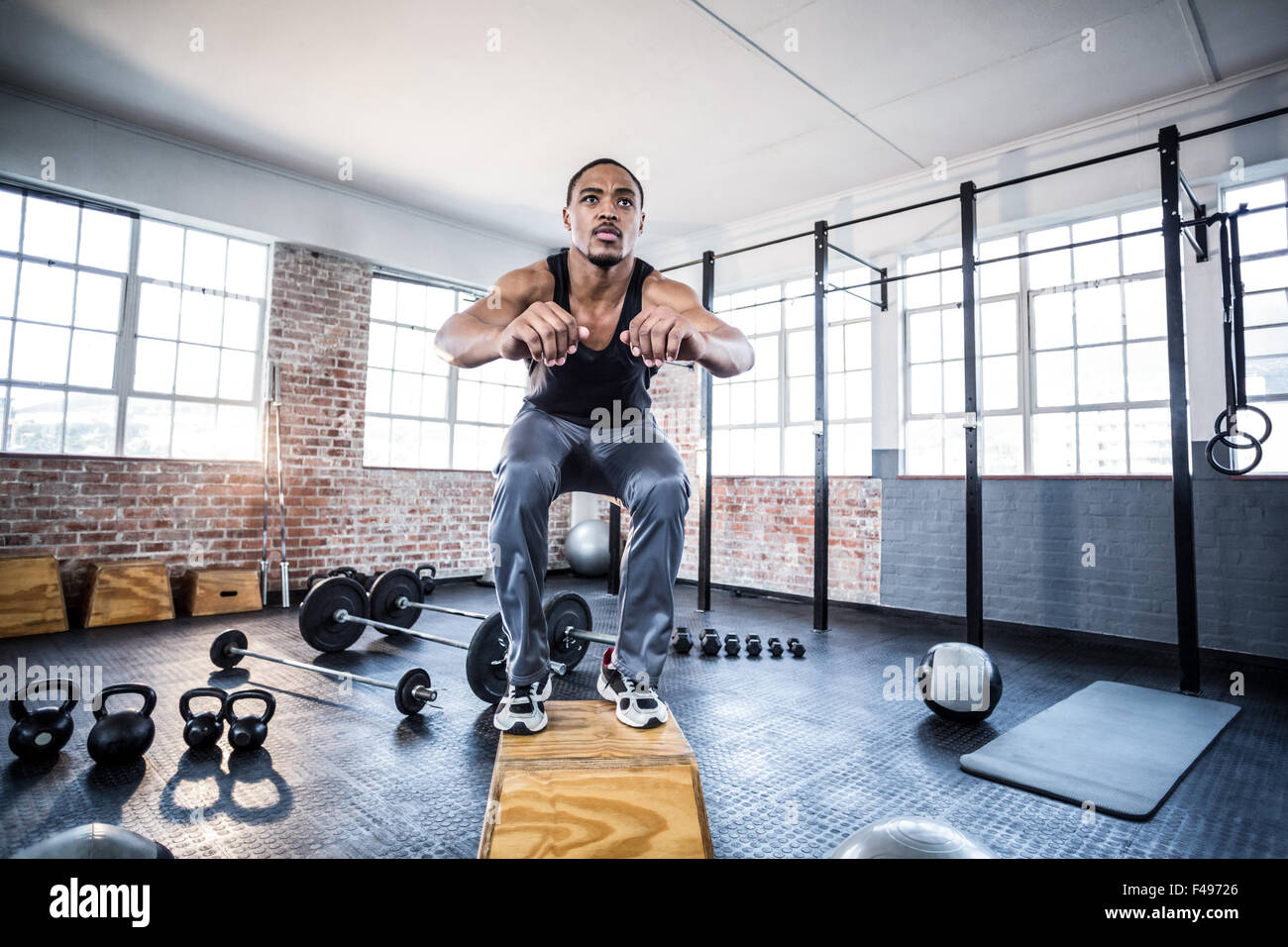 Muscular man doing stretching exercises on box Stock Photo - Alamy
