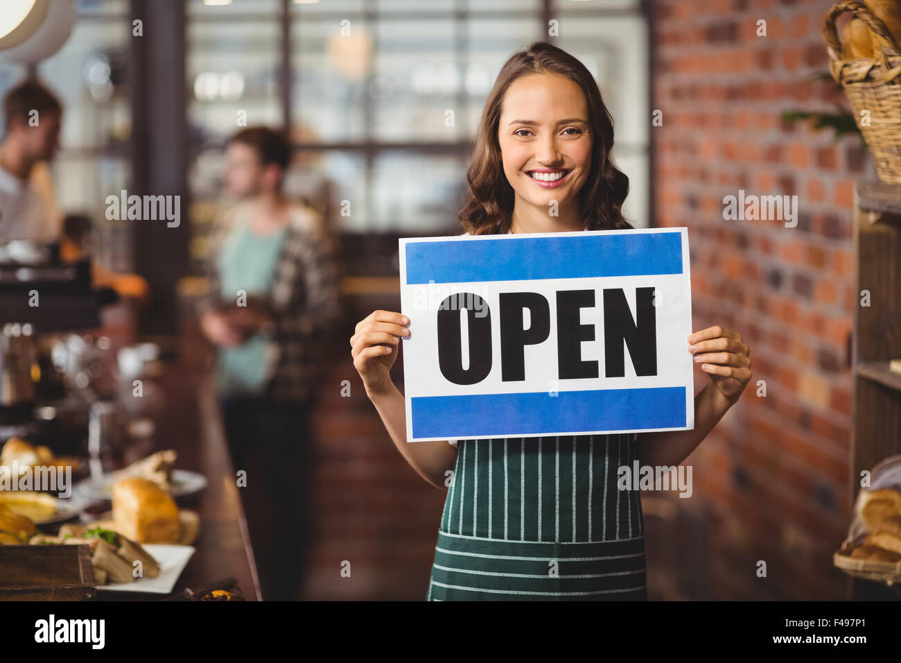 Pretty waitress posing with open sign Stock Photo - Alamy