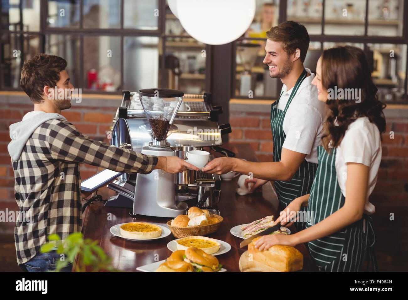 Smiling waiters serving a client Stock Photo - Alamy