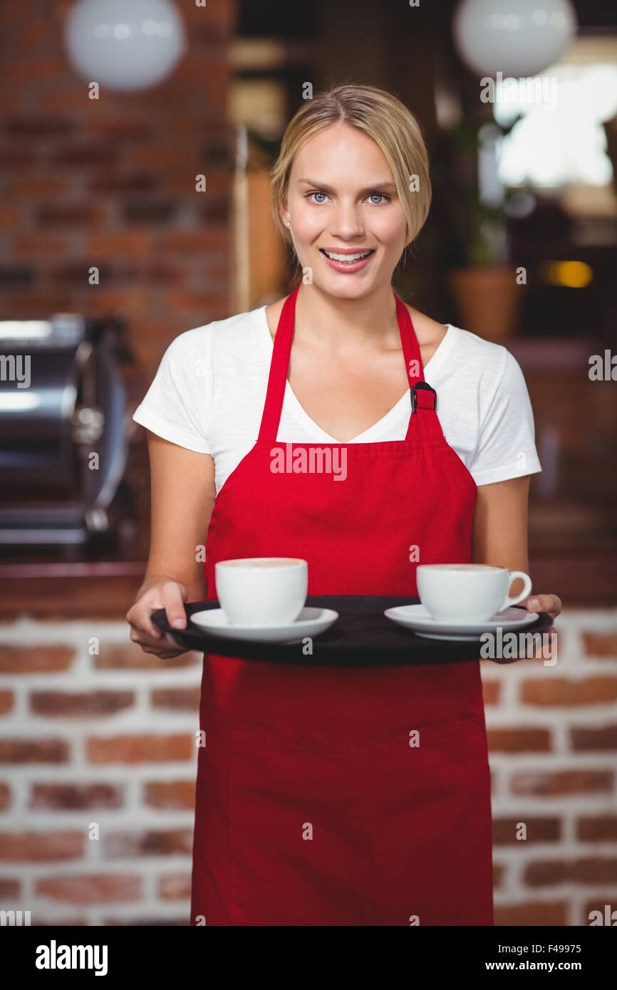 Pretty waitress holding a tray with coffees Stock Photo - Alamy