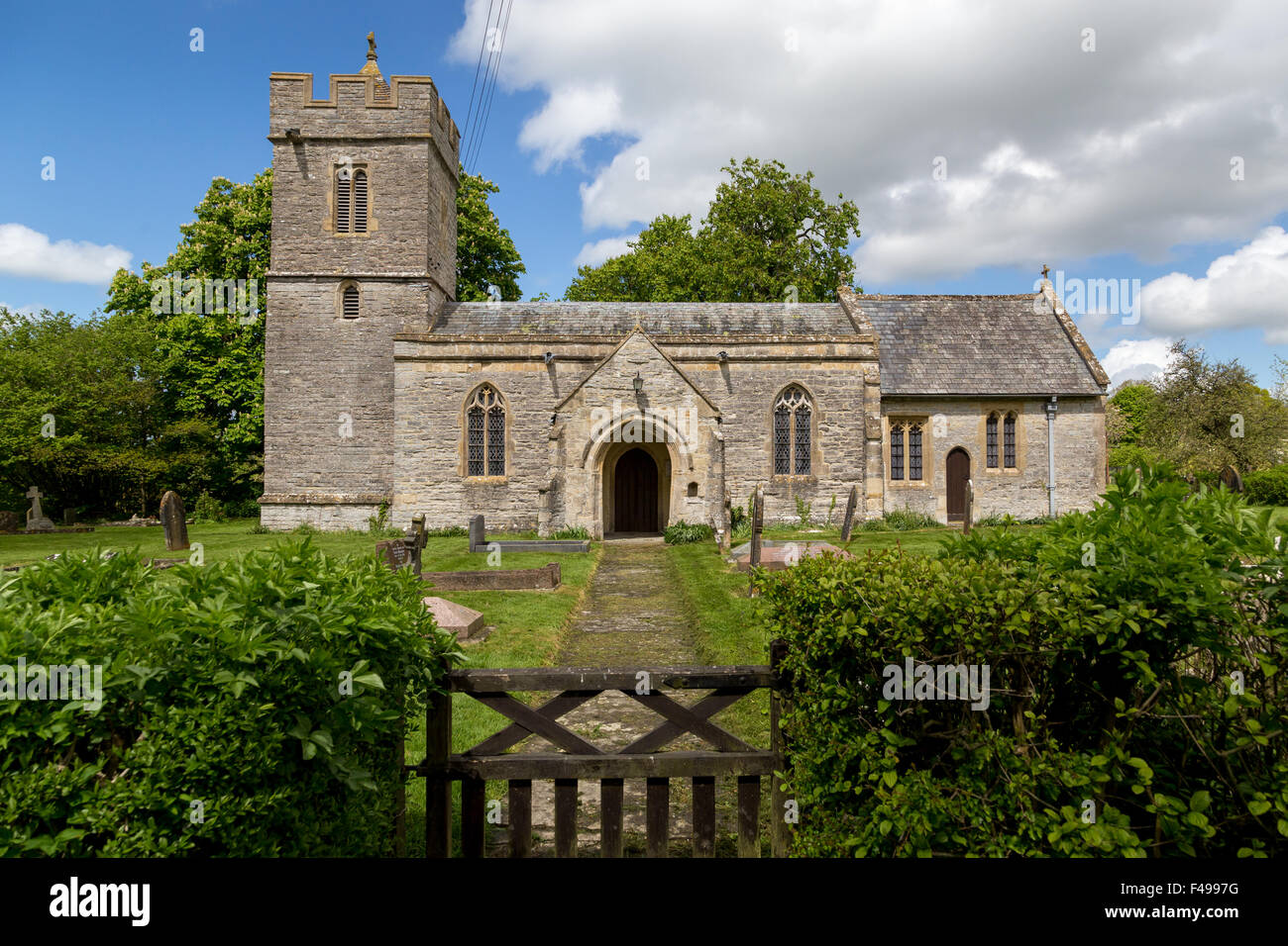 North Bradley Church and graveyard in Spring against green grass and ...