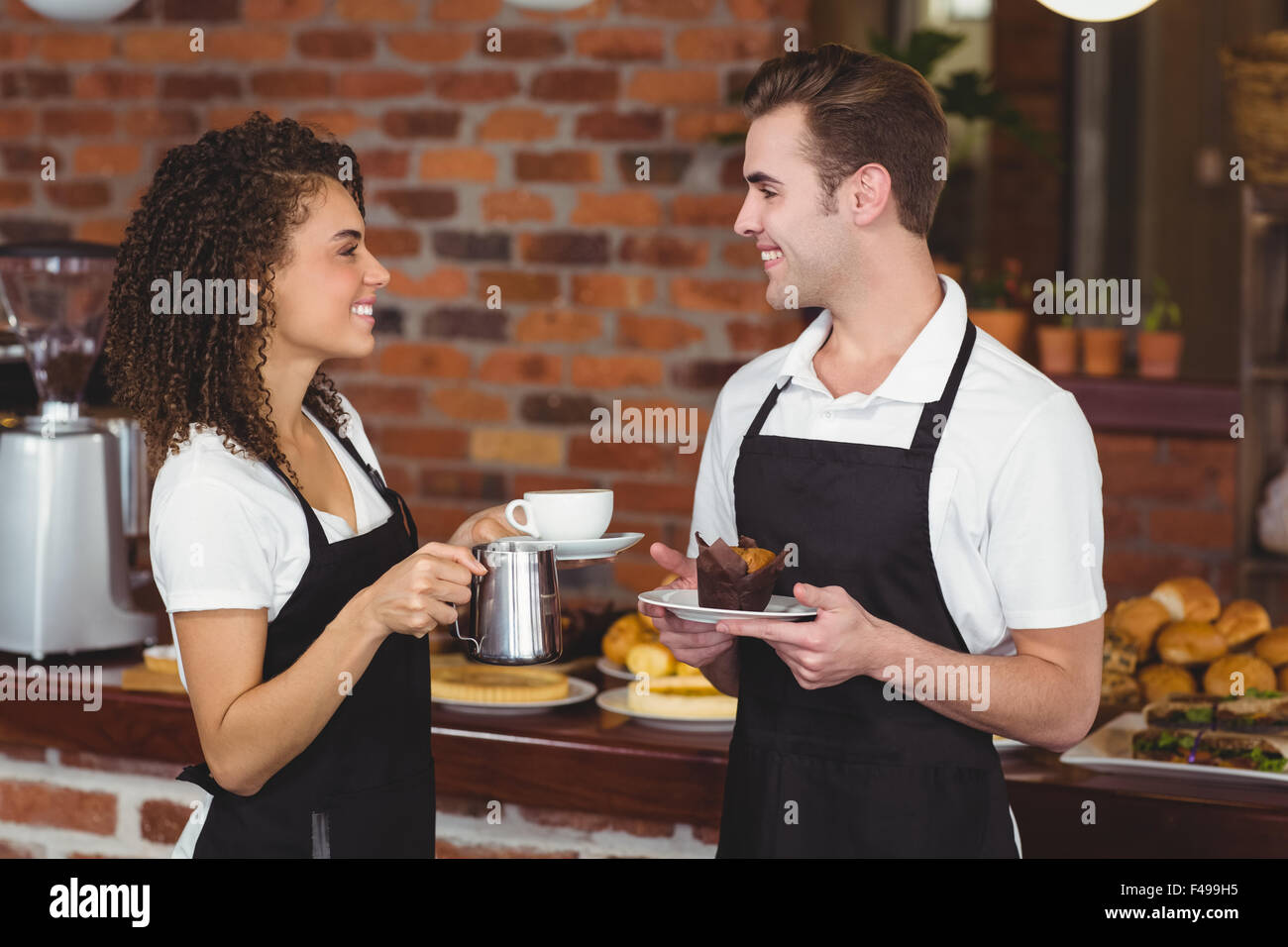 Waiter and waitress smiling at each other Stock Photo - Alamy