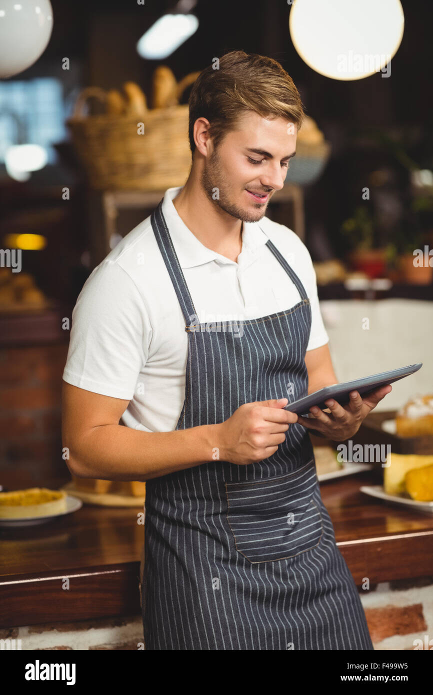 Handsome waiter using a tablet Stock Photo - Alamy