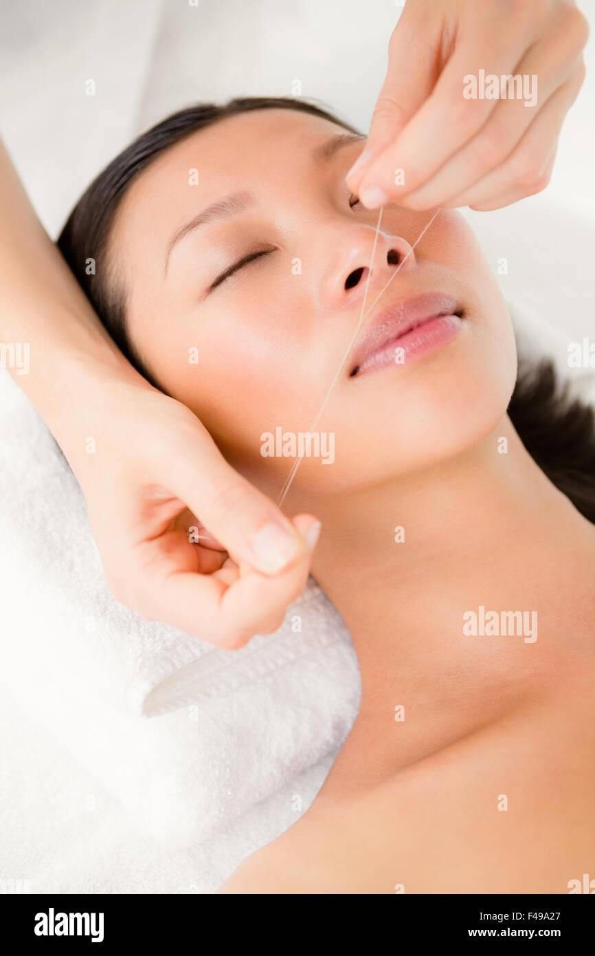 Hands threading beautiful womans face Stock Photo - Alamy