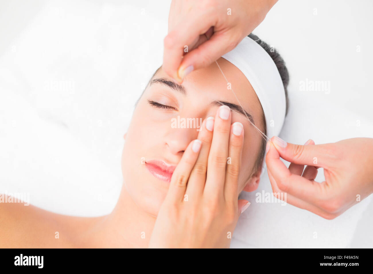 Hands threading beautiful womans upper eyes Stock Photo - Alamy