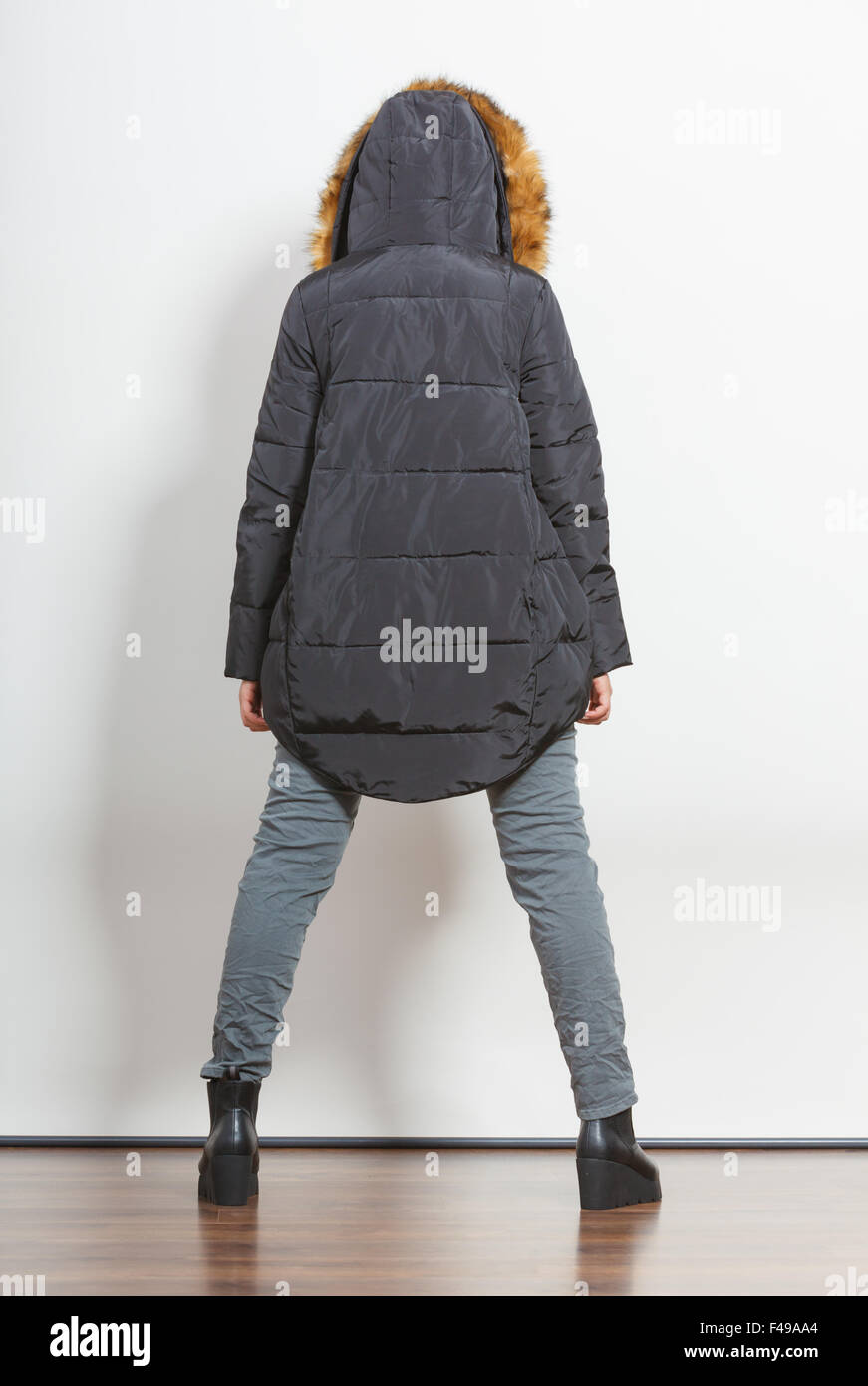 Back view of young fashionable girl wearing jacket with hood. Fashion ...