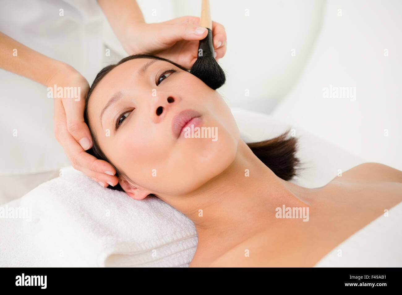Hand applying blush to beautiful woman Stock Photo - Alamy