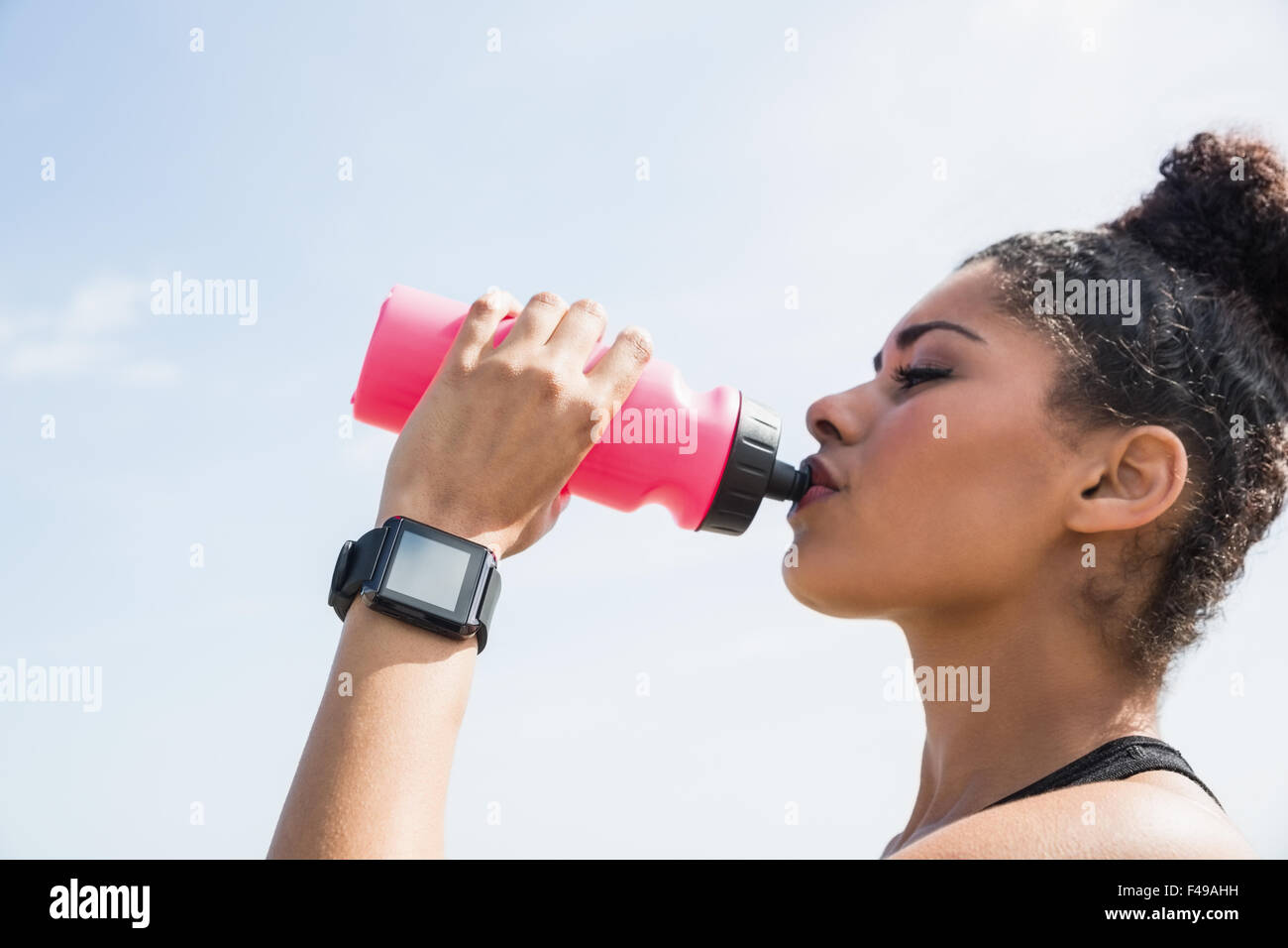 Fit woman wearing smart watch and drinking Stock Photo - Alamy