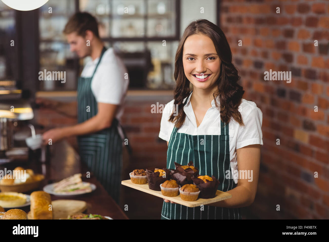 Pretty waitress holding a tray of muffins Stock Photo - Alamy