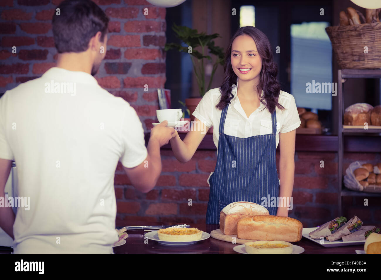 Pretty smiling barista serving a customer Stock Photo - Alamy