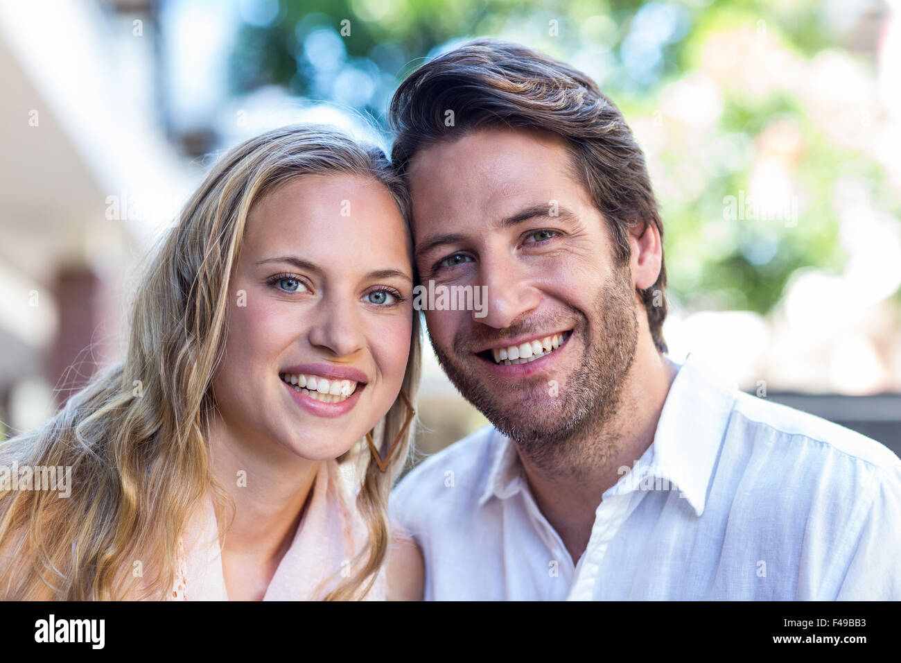Smiling couple sitting closely together Stock Photo - Alamy