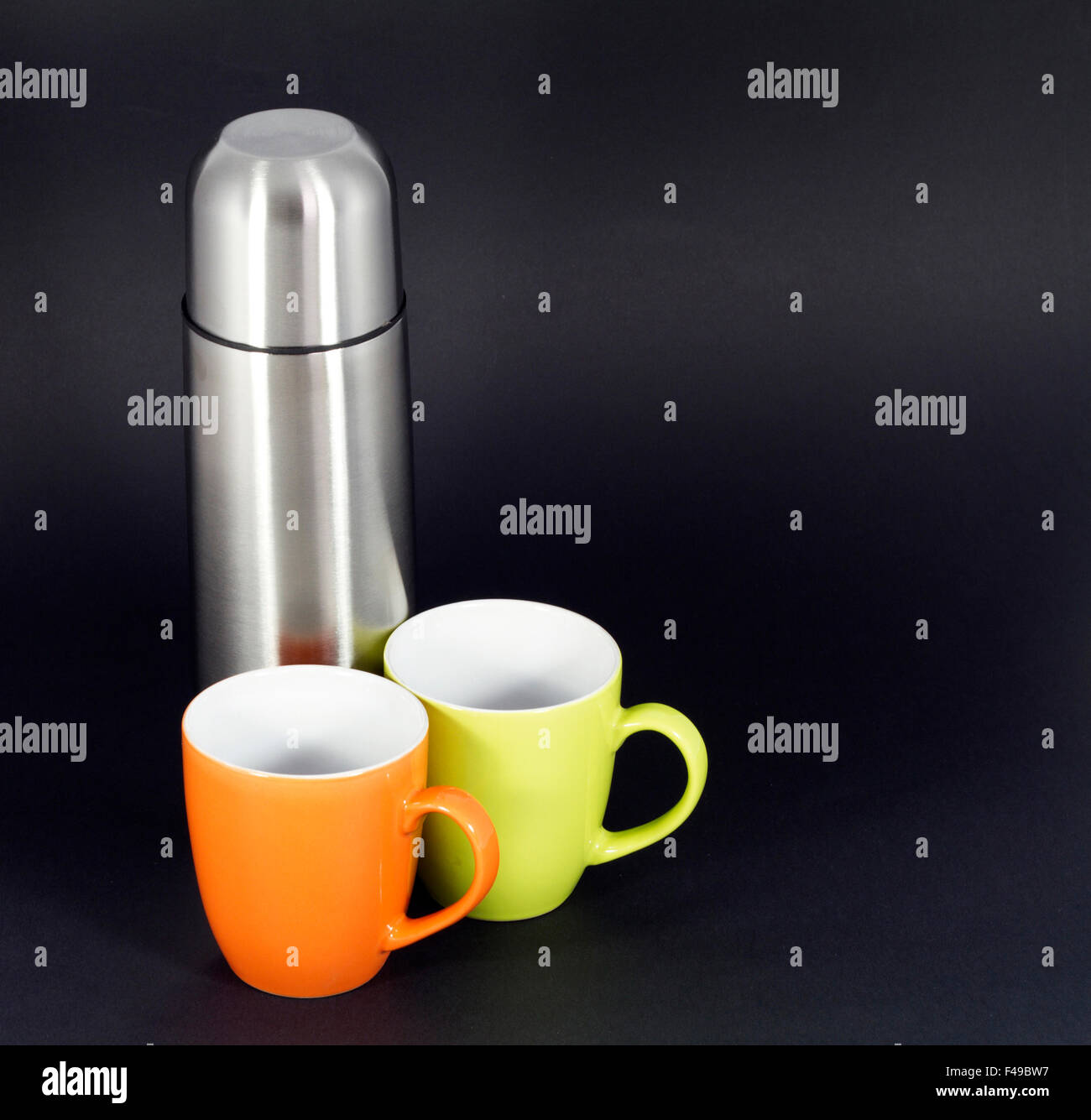 Thermos whit colorful cups in black background Stock Photo - Alamy