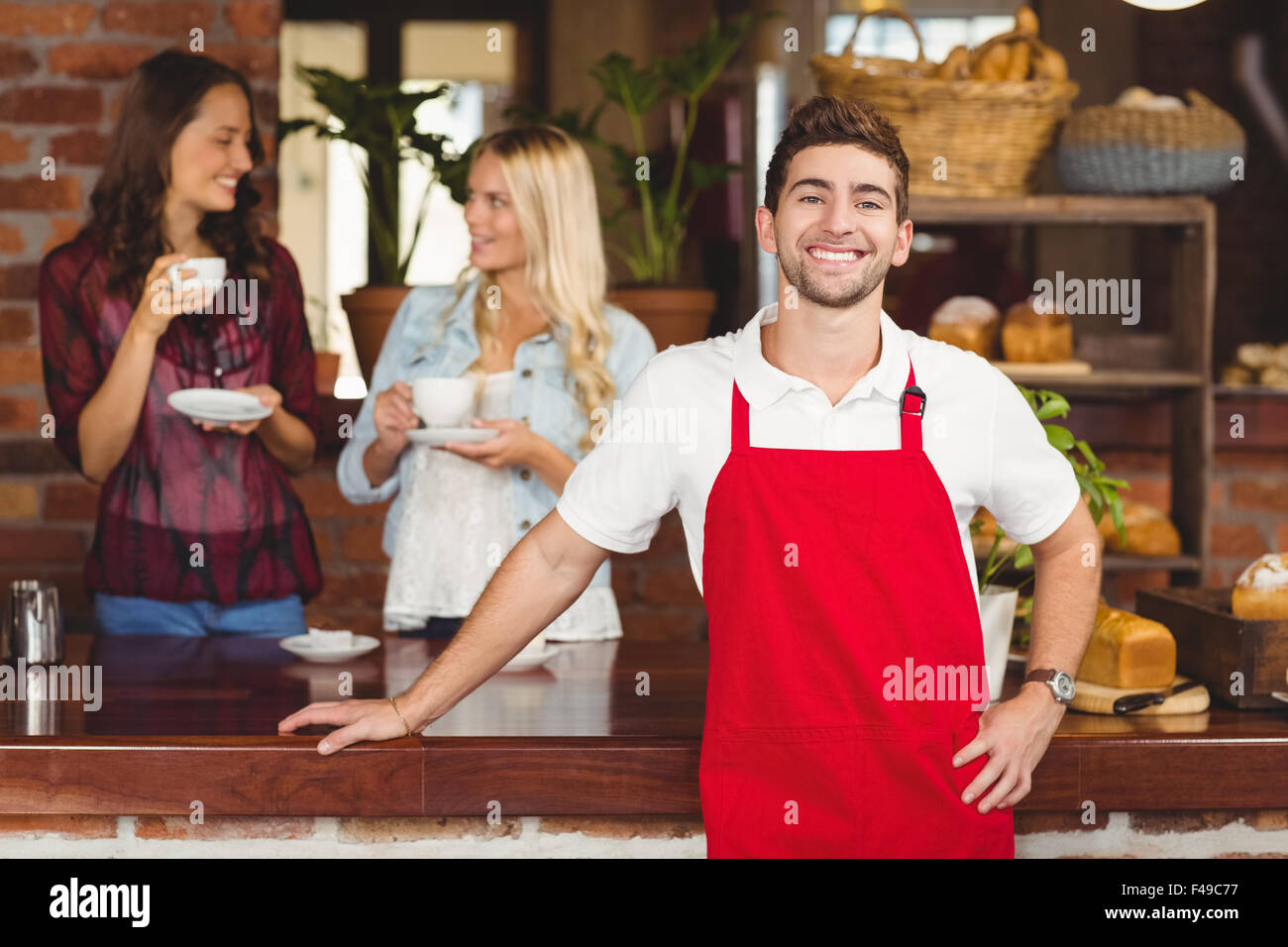 Handsome waiter leaning on the counter Stock Photo - Alamy
