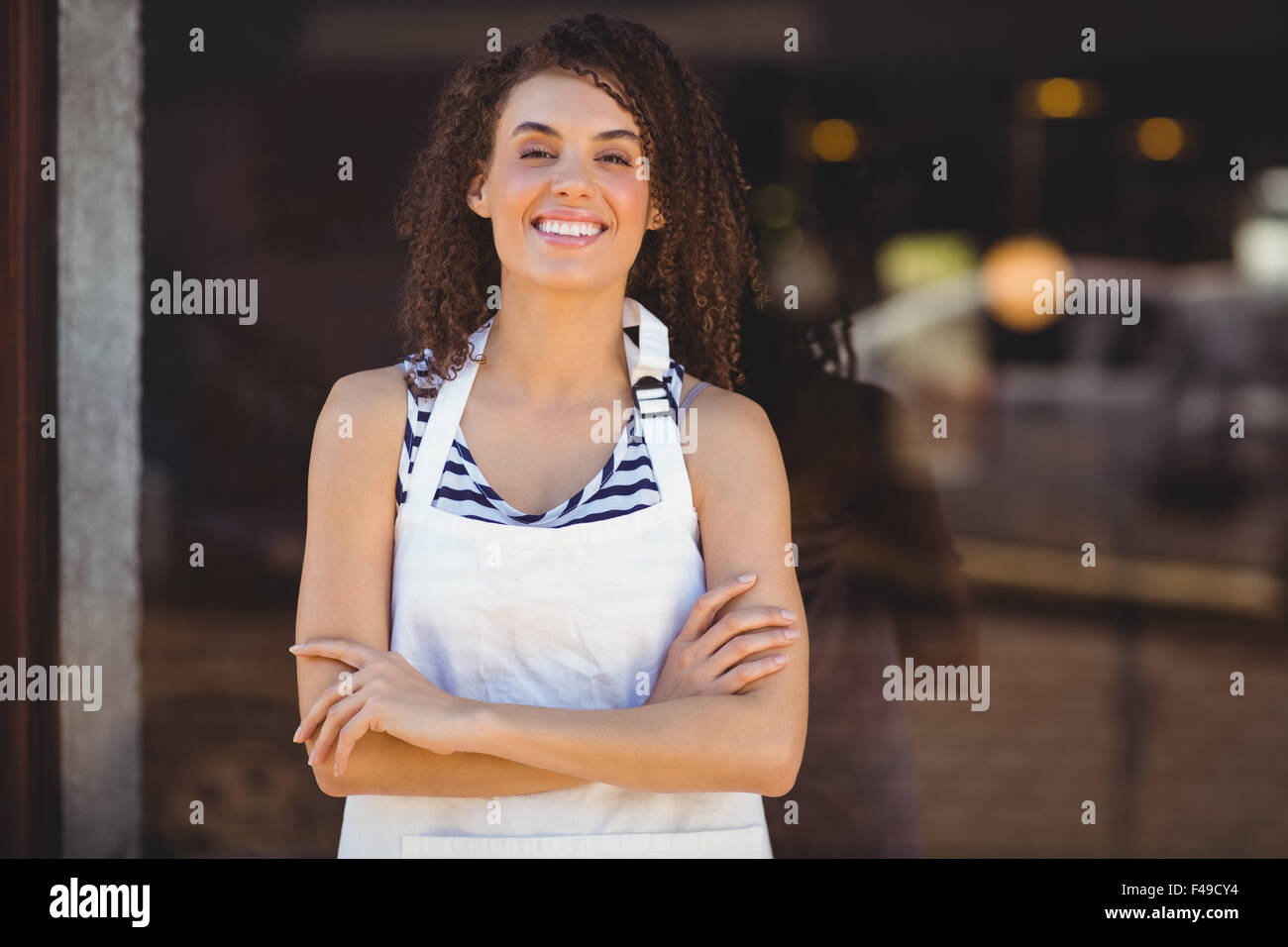 Smiling waitress with arms crossed Stock Photo - Alamy