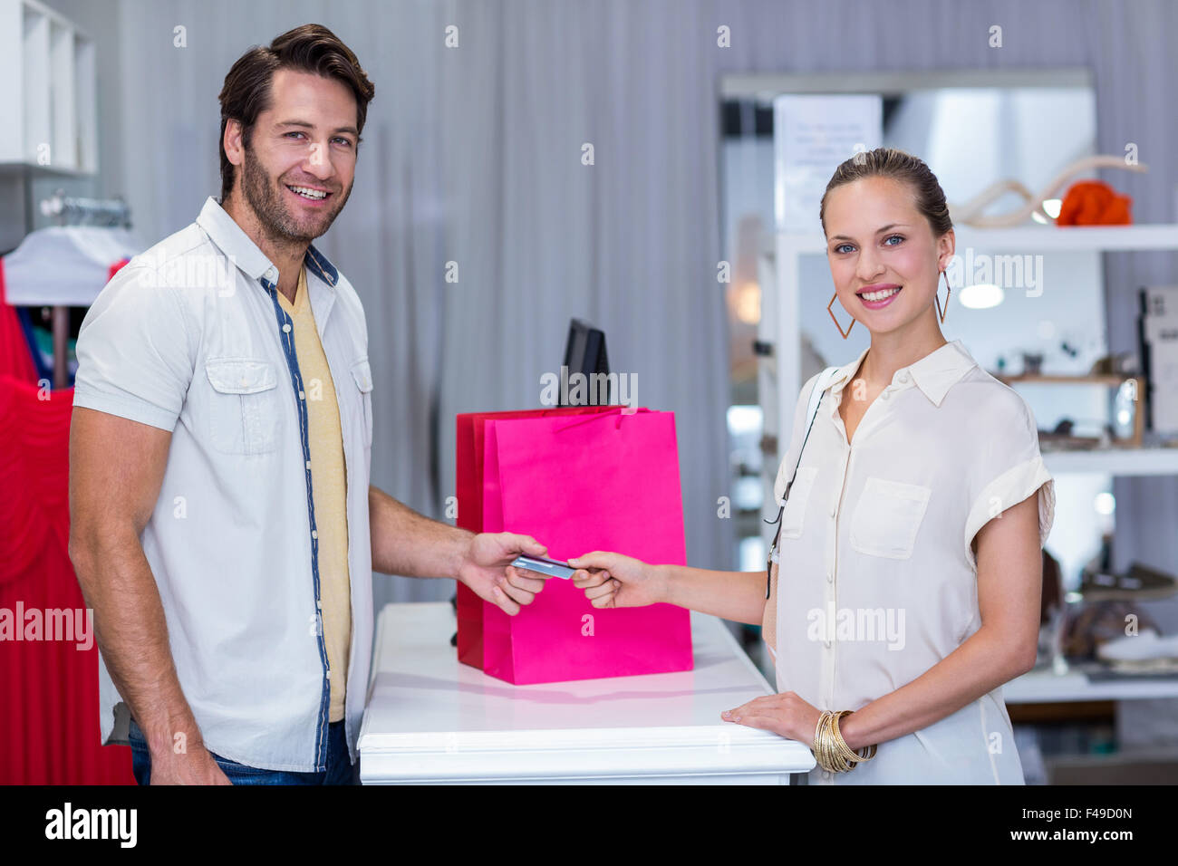 Smiling woman giving credit card to cashier Stock Photo - Alamy