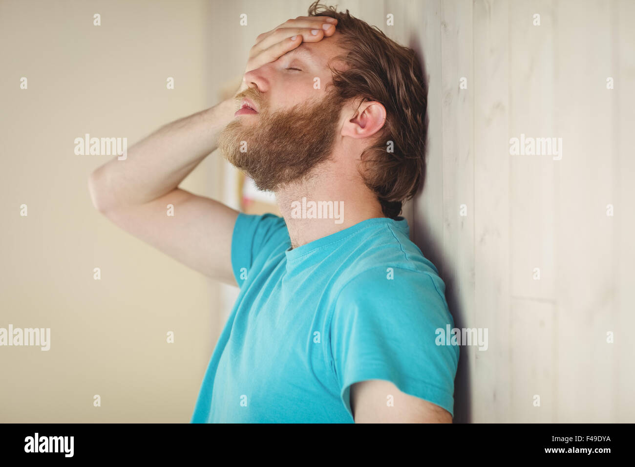 Young man leaning against wooden wall hi-res stock photography and ...