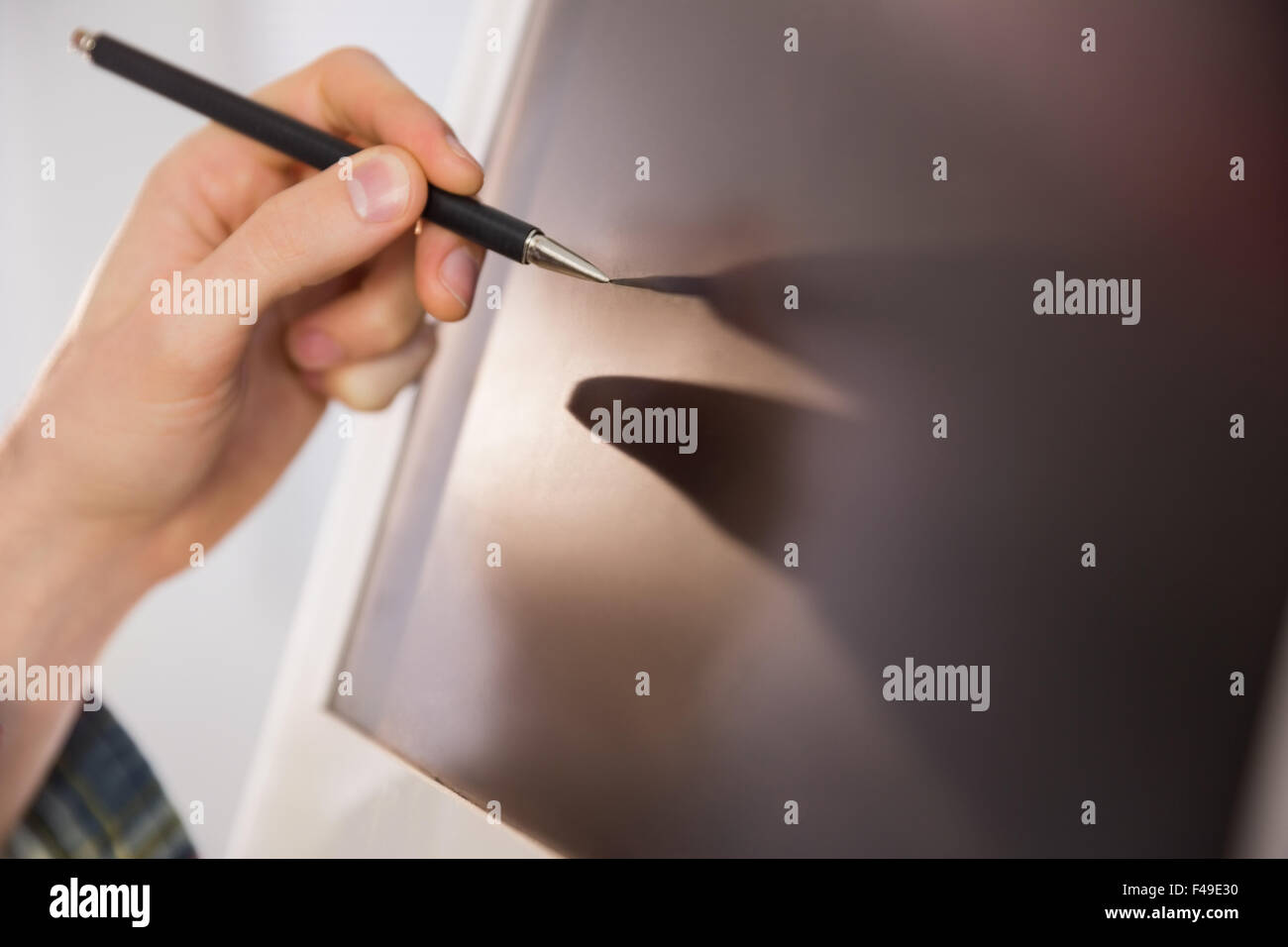 Businessman pointing at computer with pen Stock Photo - Alamy