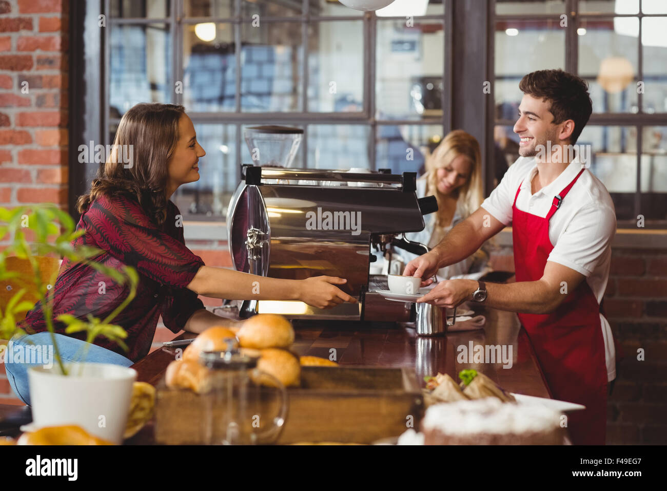 A smiling barista serving a client Stock Photo - Alamy