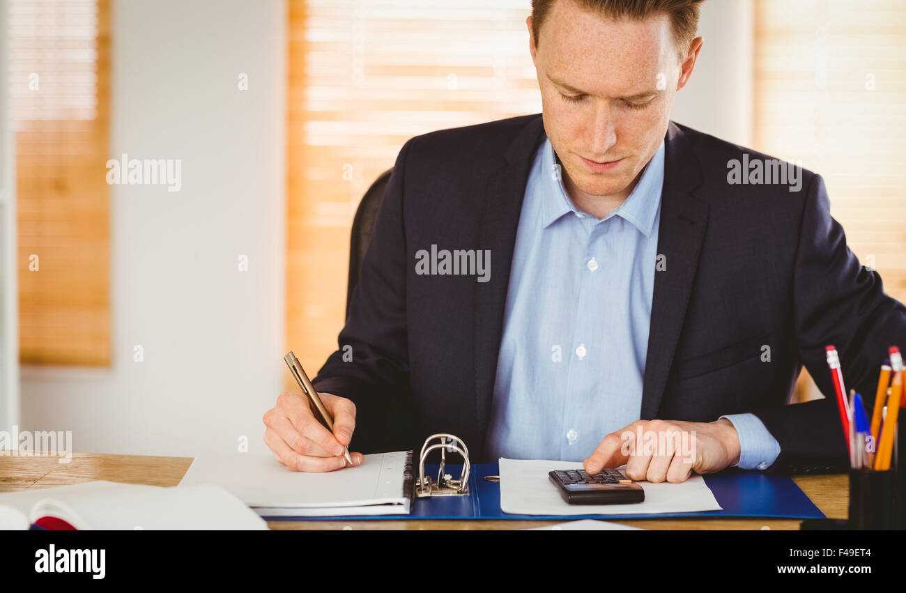 Concentrated businessman writing down Stock Photo - Alamy