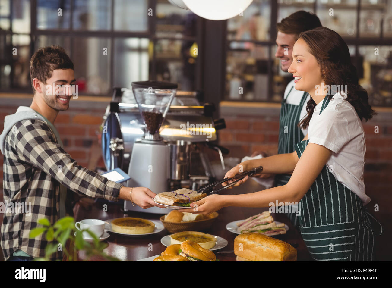 Smiling waiters serving a client Stock Photo - Alamy