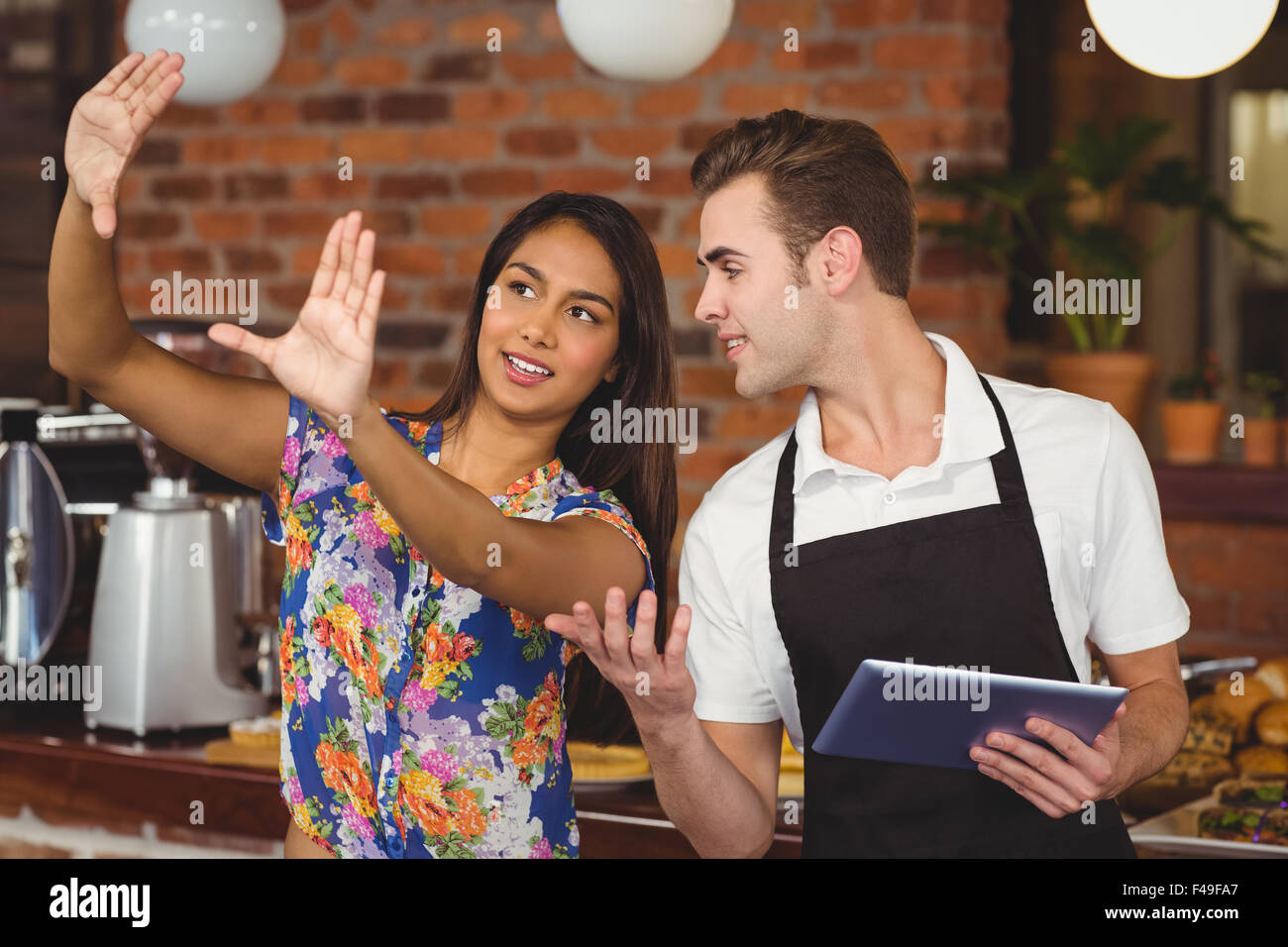 Pretty customer explaining to waiter Stock Photo - Alamy