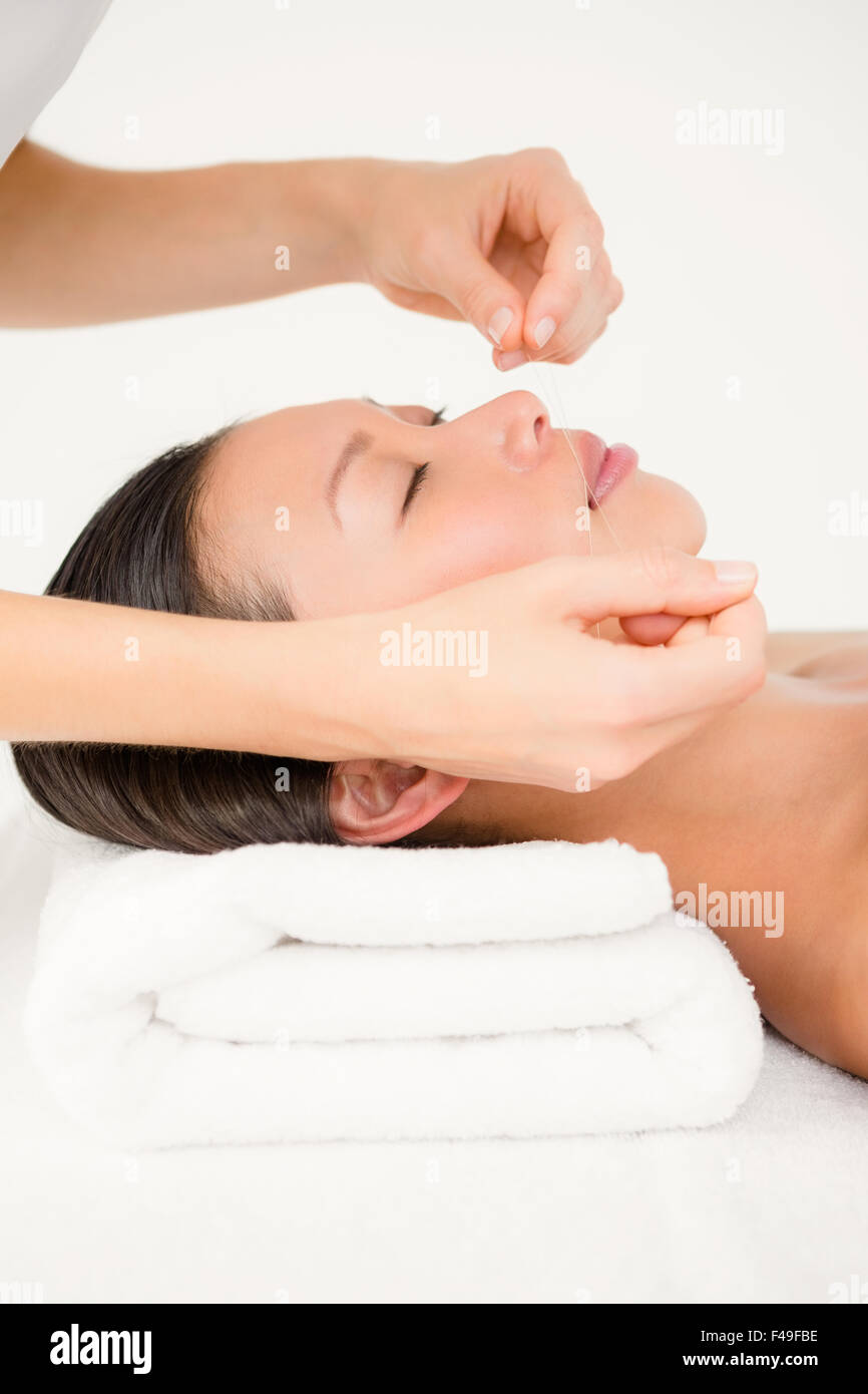 Hands threading beautiful womans face Stock Photo - Alamy