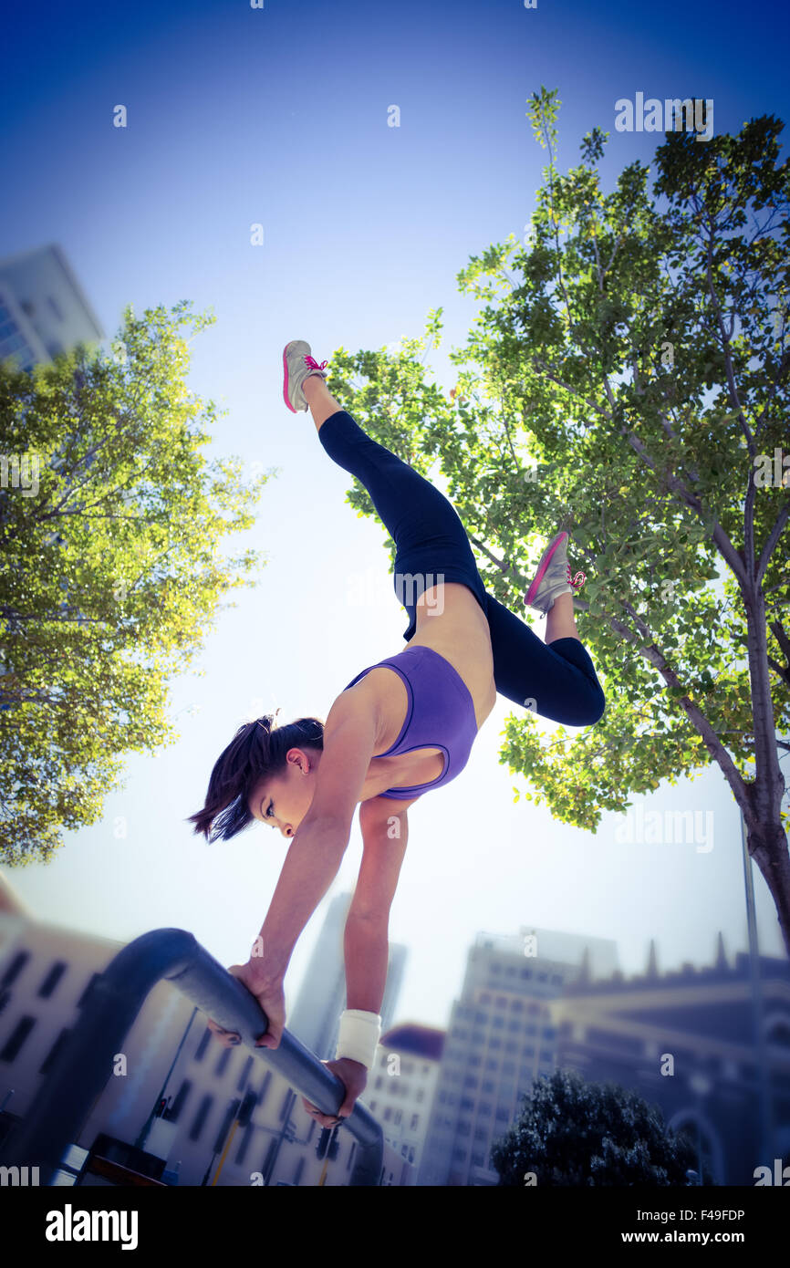 Athletic woman performing handstand on bar Stock Photo - Alamy