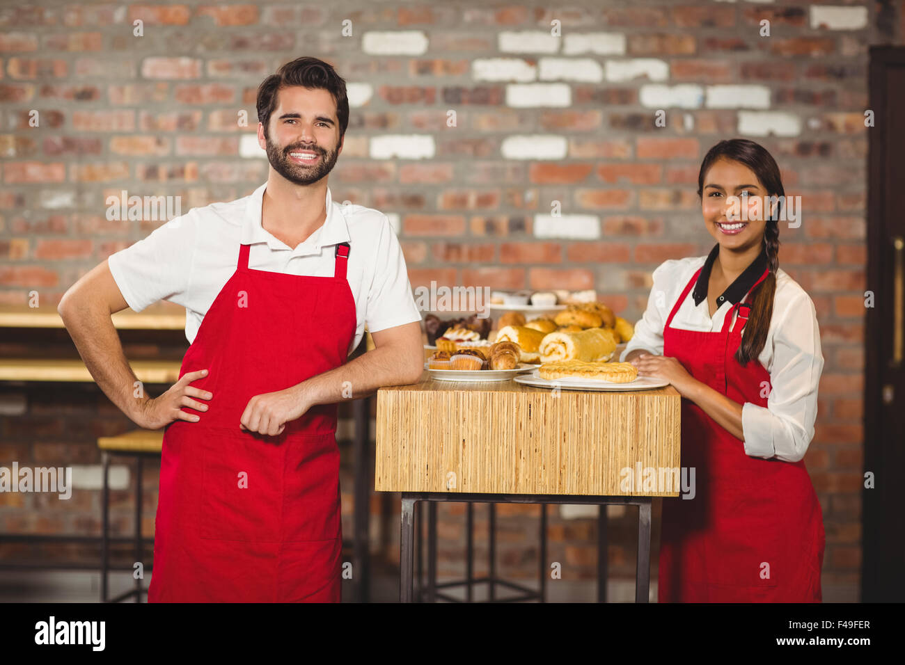 Two smiling waiters looking at the camera Stock Photo - Alamy