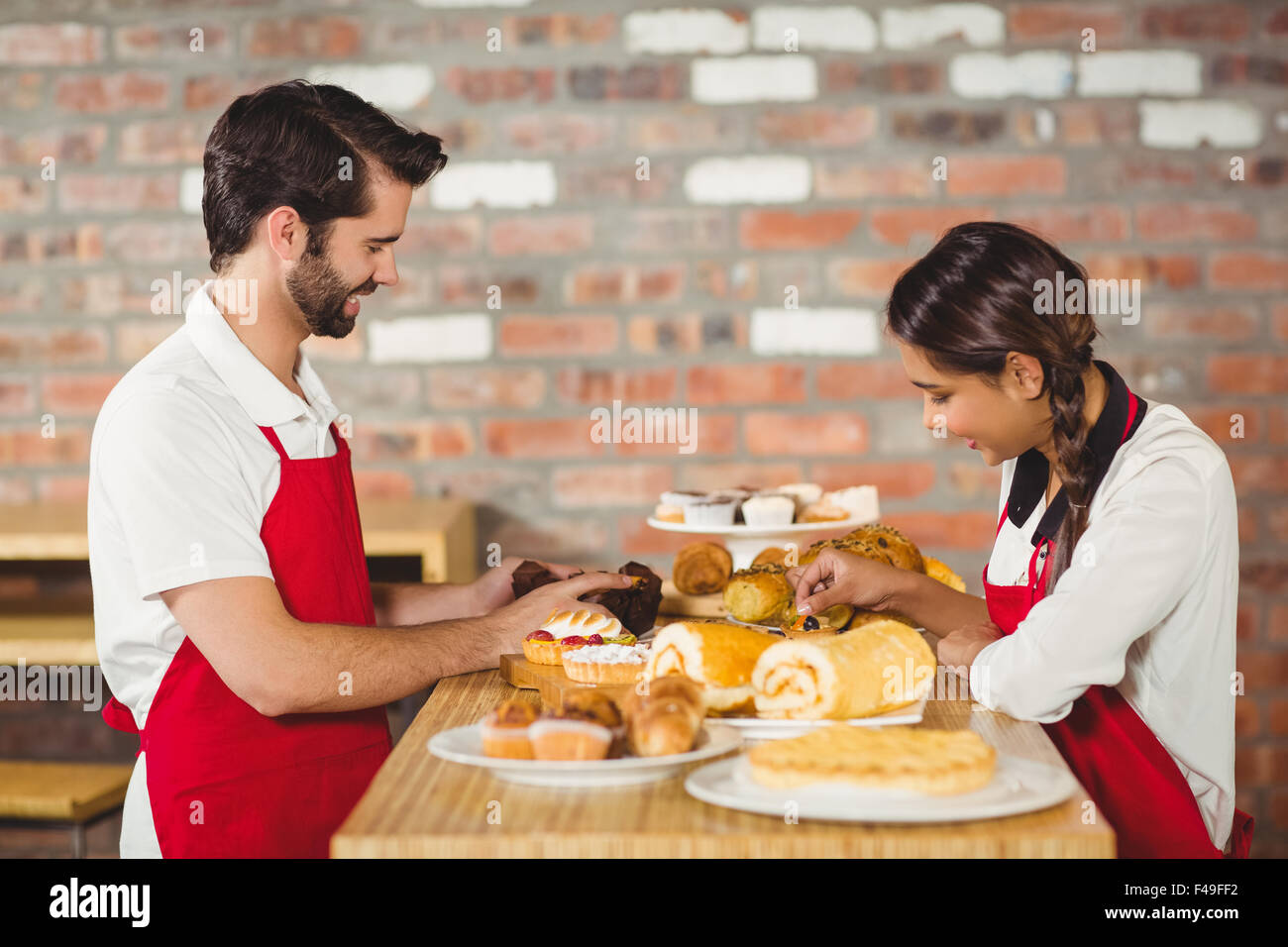 Waiters tidying up pastries on the counter Stock Photo - Alamy
