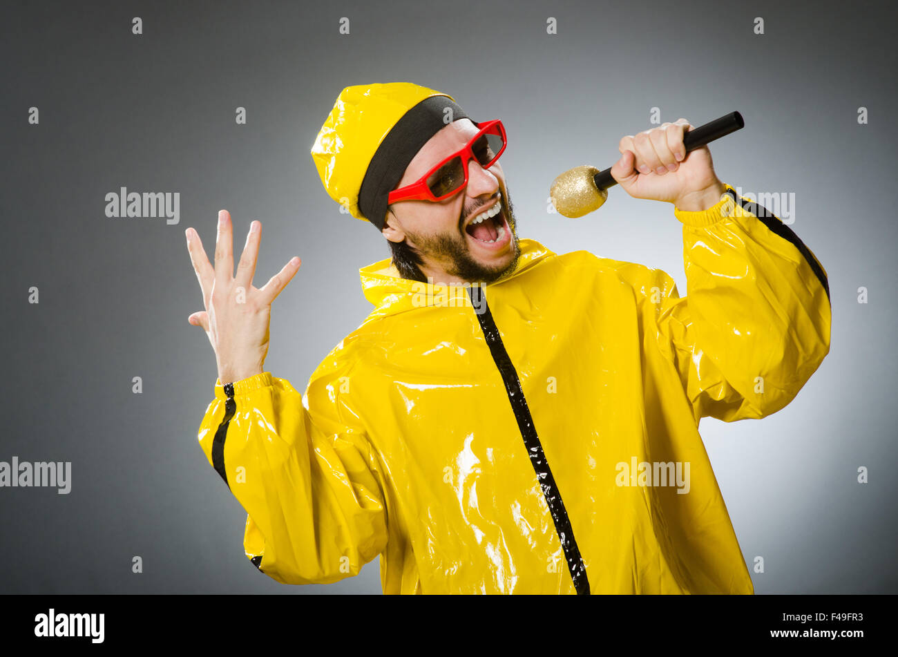 Man wearing yellow suit with mic Stock Photo - Alamy