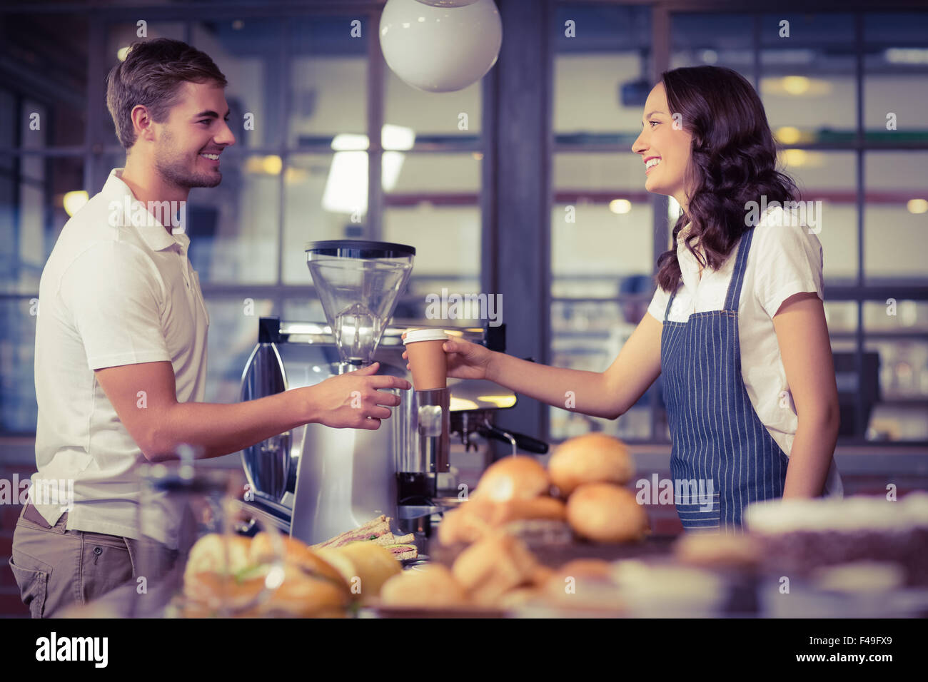 Pretty smiling barista serving a customer Stock Photo - Alamy