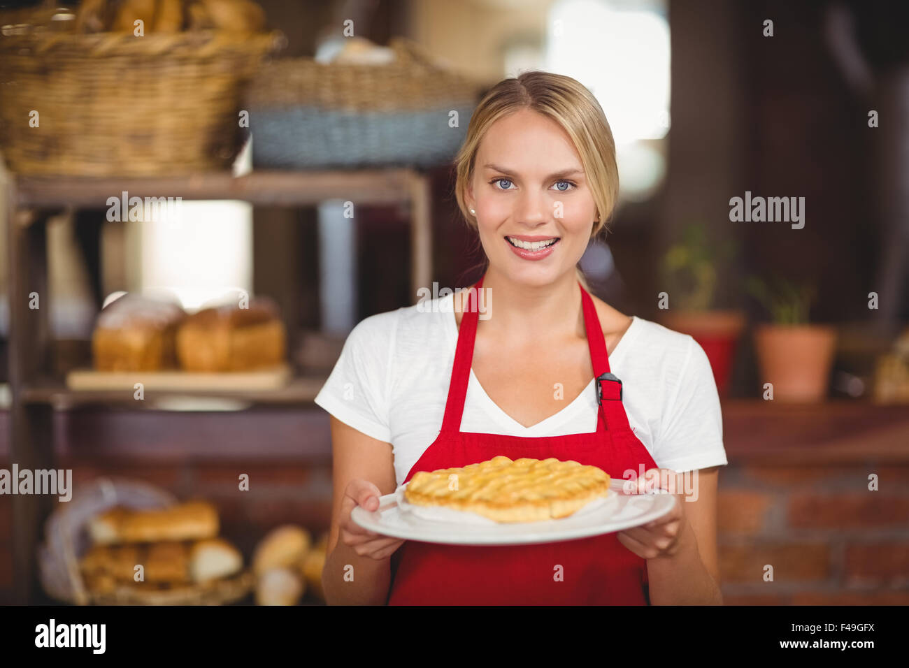 Pretty waitress holding a plate of cake Stock Photo - Alamy