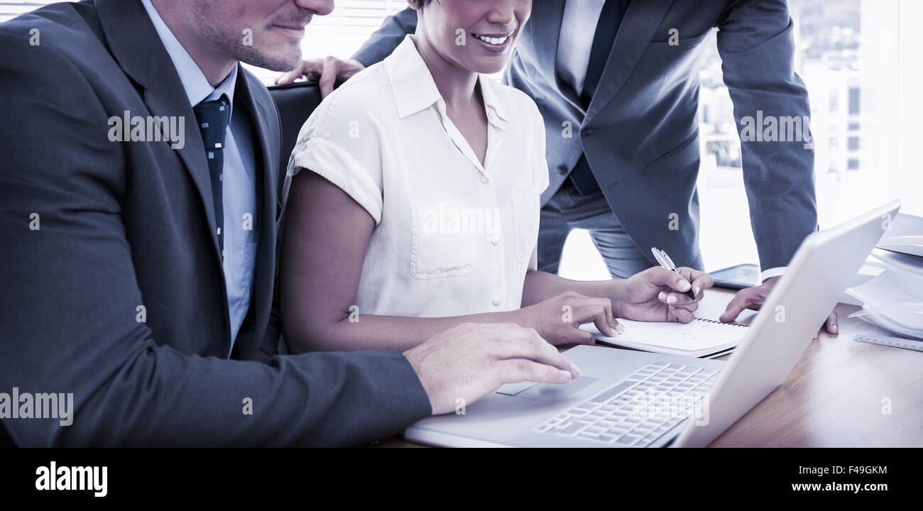 Young colleagues using laptop at office desk Stock Photo - Alamy