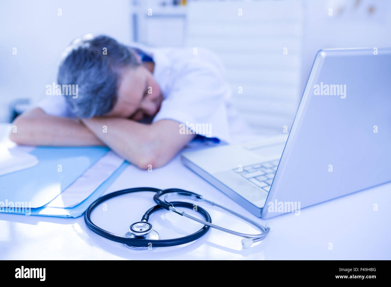 Female doctor sleeping on desk Stock Photo - Alamy