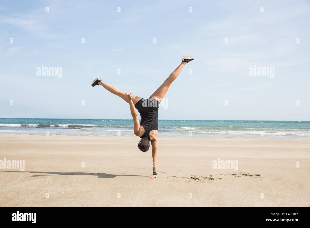 Fit woman cartwheeling on the sand Stock Photo - Alamy