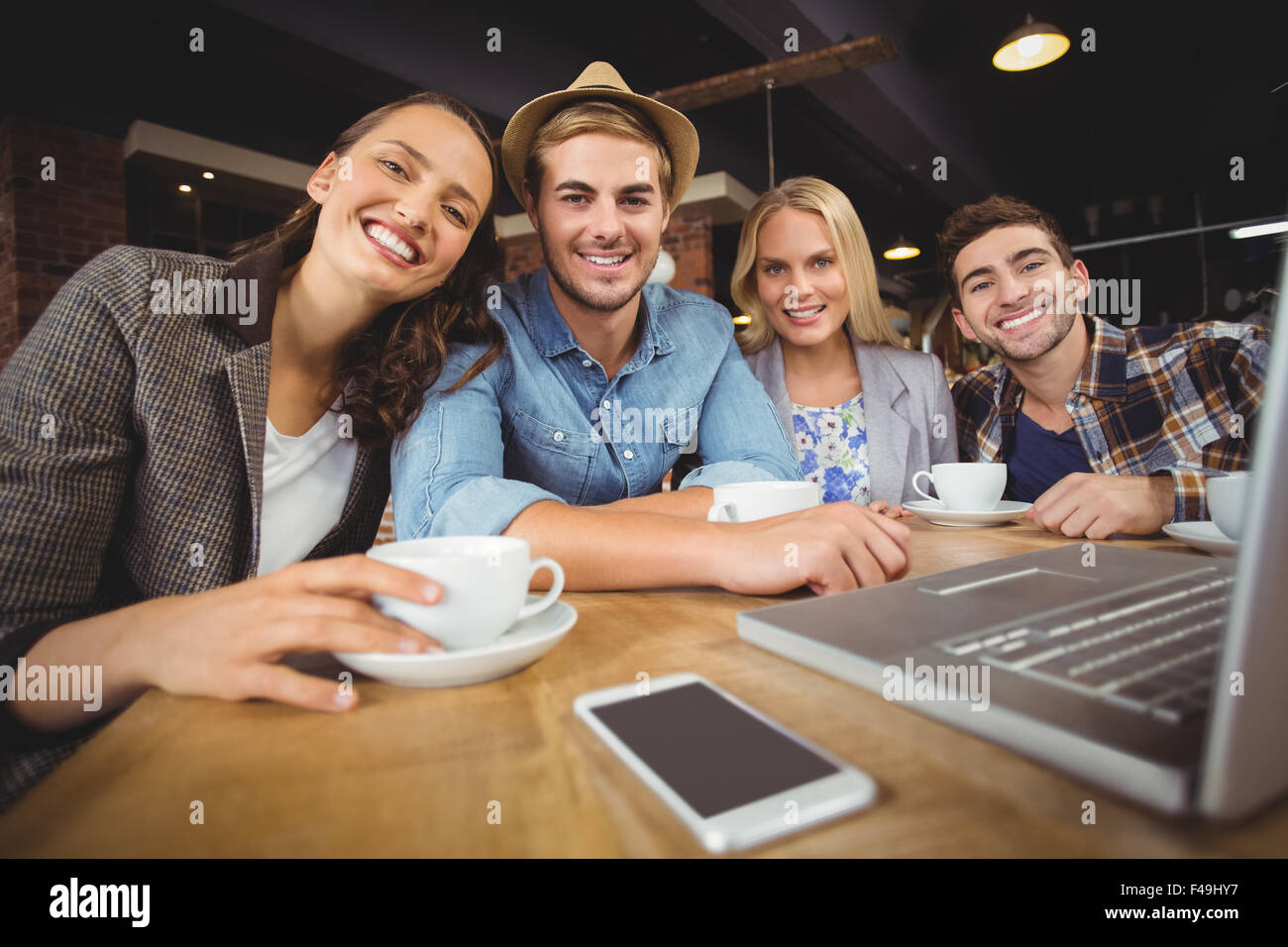 Smiling friends having coffee together Stock Photo - Alamy