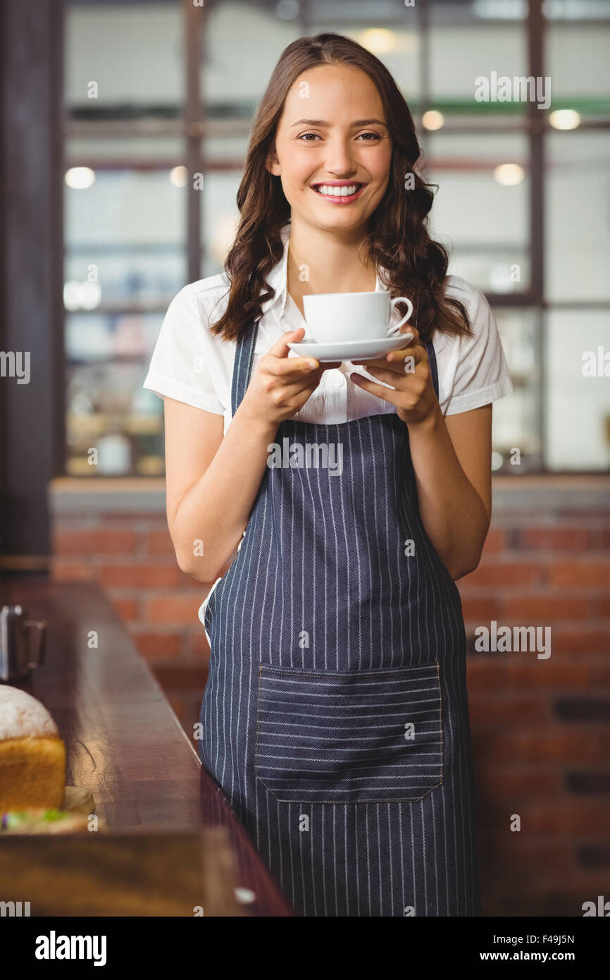 Pretty waitress offering a cup of coffee Stock Photo - Alamy