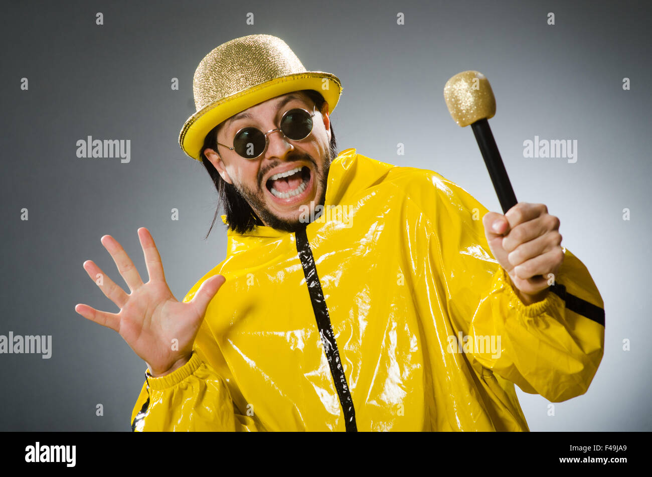Man wearing yellow suit with mic Stock Photo - Alamy