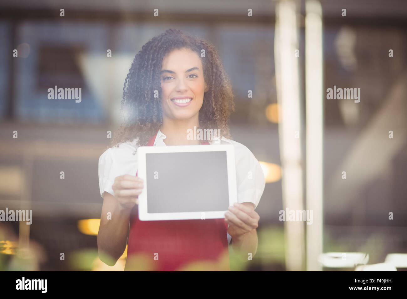 Smiling waitress showing a digital tablet Stock Photo - Alamy