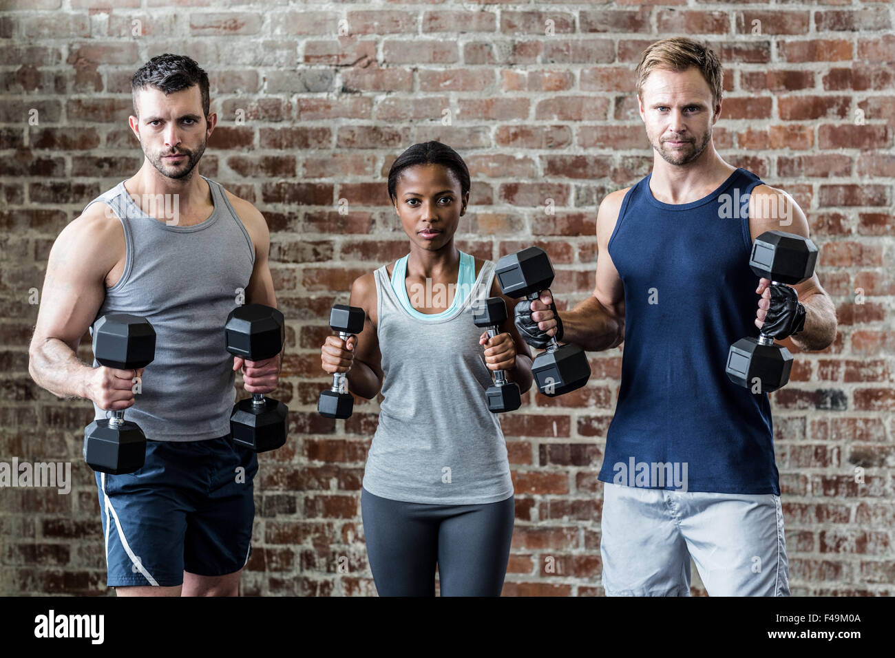 Fit people lifting dumbbells together Stock Photo - Alamy