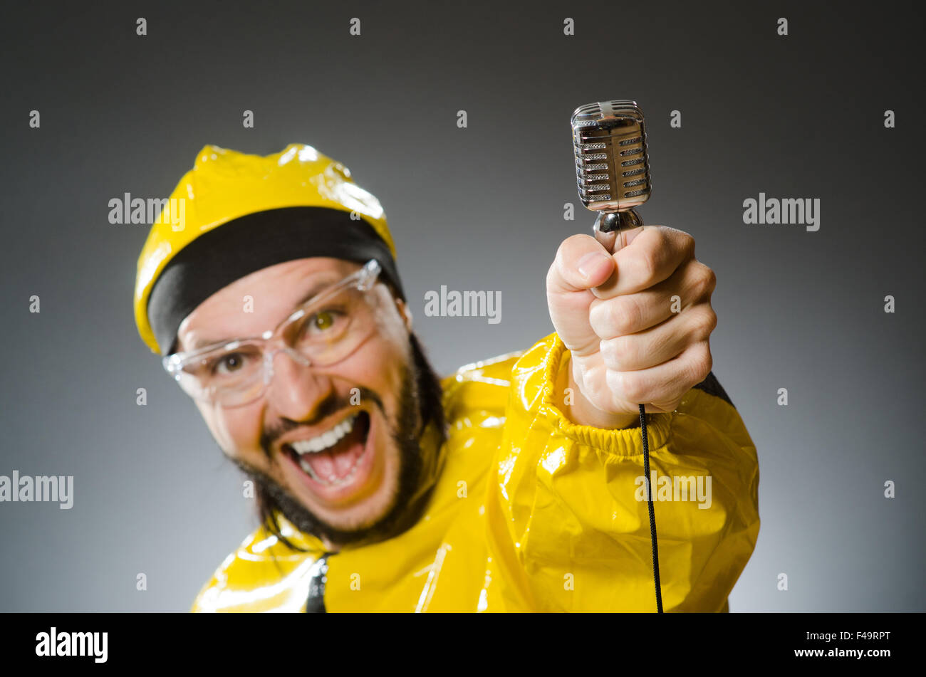 Man wearing yellow suit with mic Stock Photo - Alamy