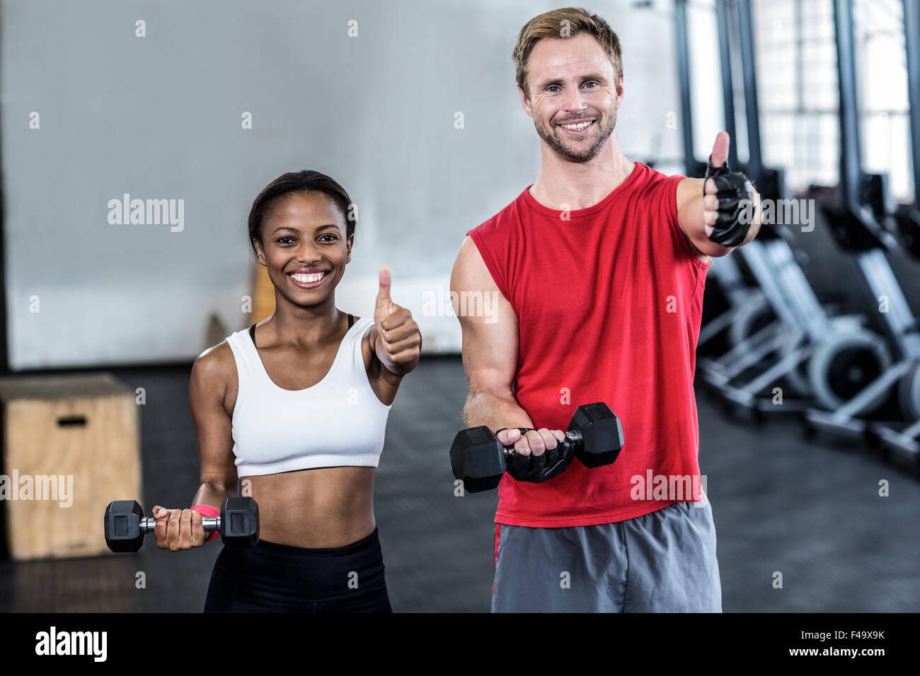Muscular couple lifting weight together Stock Photo - Alamy