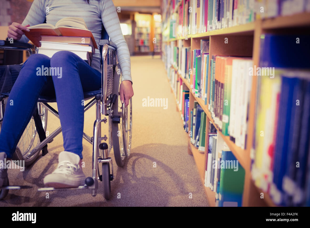 Low section of disabled student reading book Stock Photo - Alamy