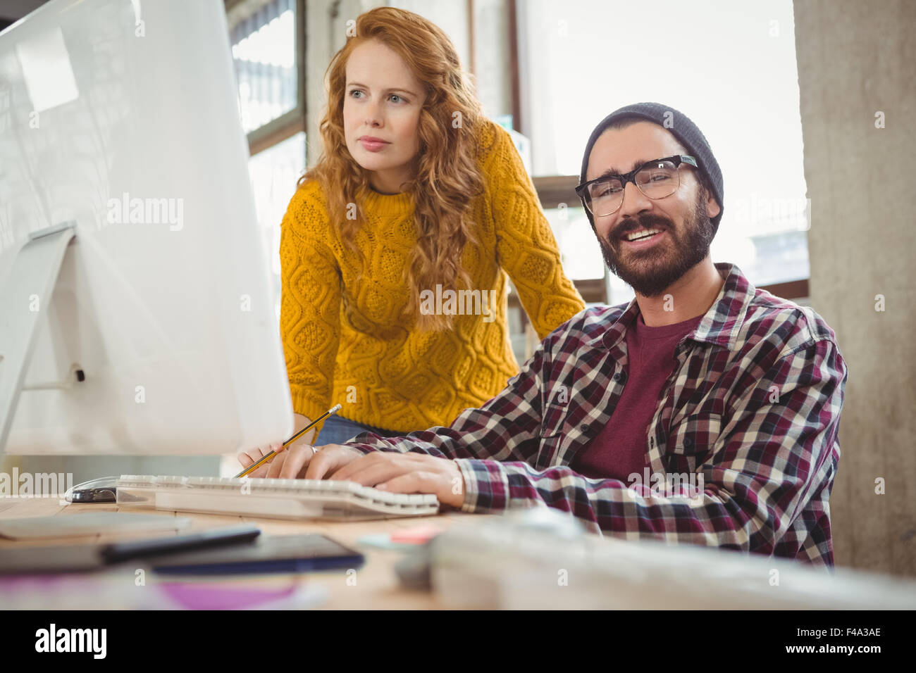 Man smiling while woman looking at computer Stock Photo - Alamy