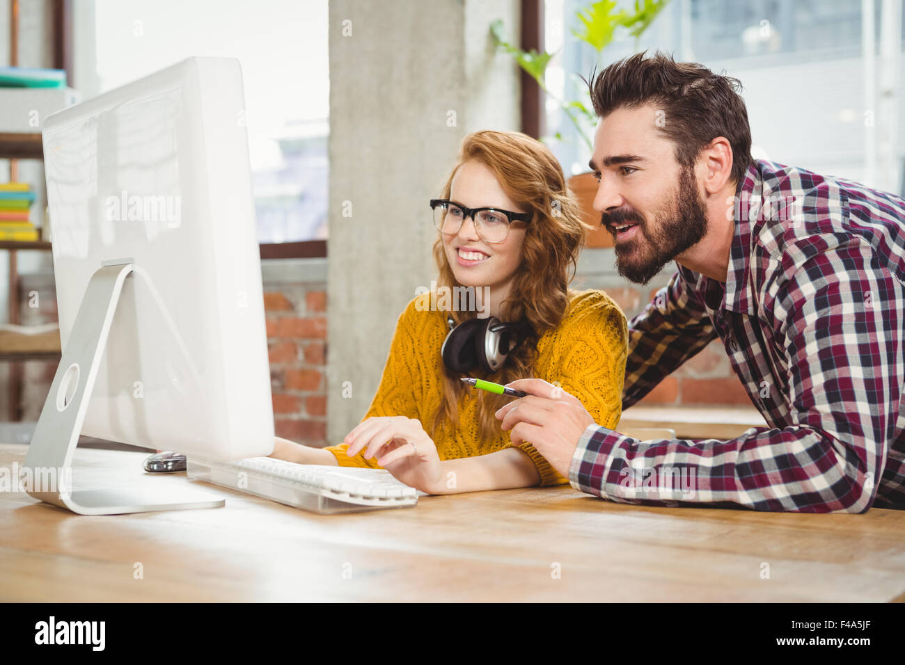 Happy colleagues working at office Stock Photo - Alamy