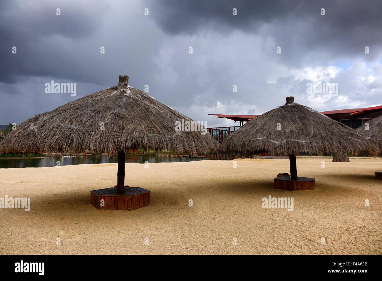 Empty beach with straw huts due to incoming storm Stock Photo - Alamy