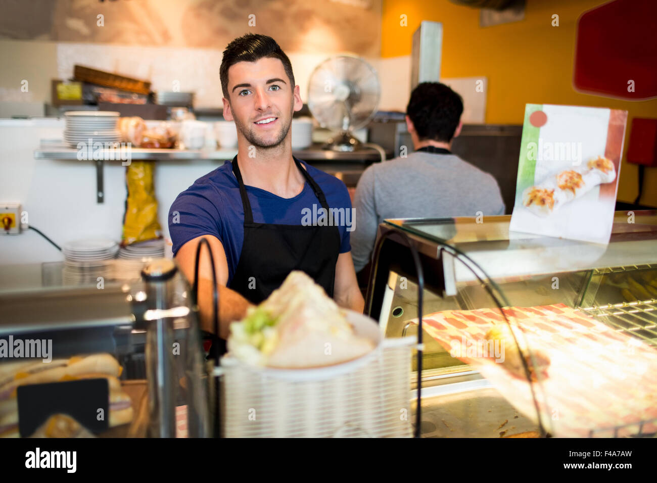 Handsome waiter offering lunch to camera Stock Photo - Alamy